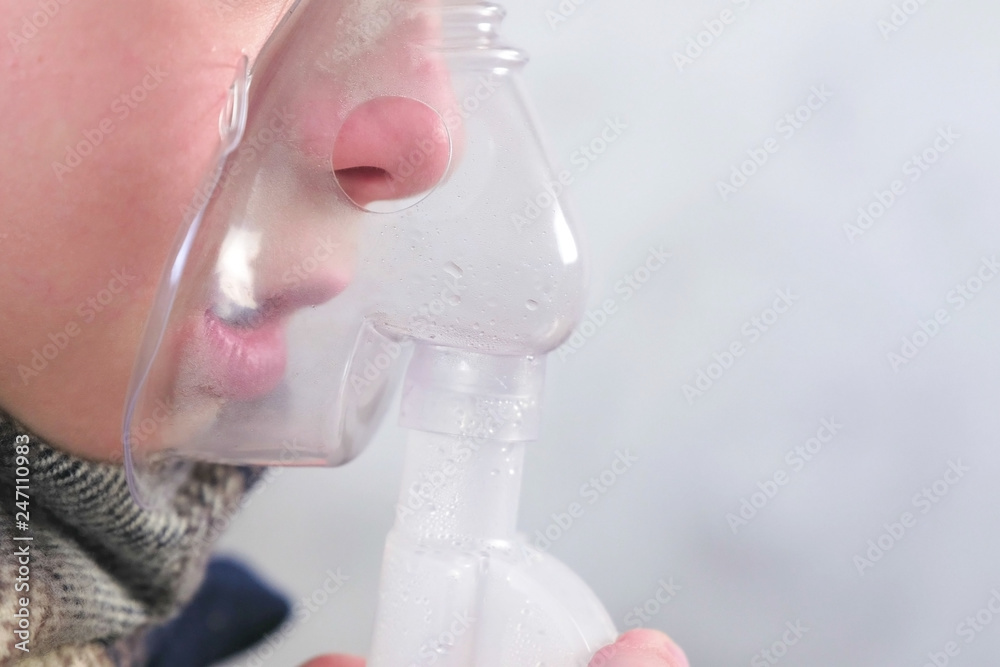 Fotka „Sick boy inhaling through inhaler mask, nose and lips close-up ...
