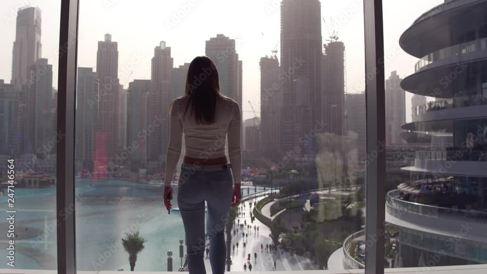 Young woman coming to the window and looking and looking down to the ...