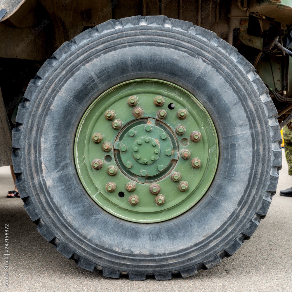 A closeup view of the wheel and tire on a large military truck. The ...