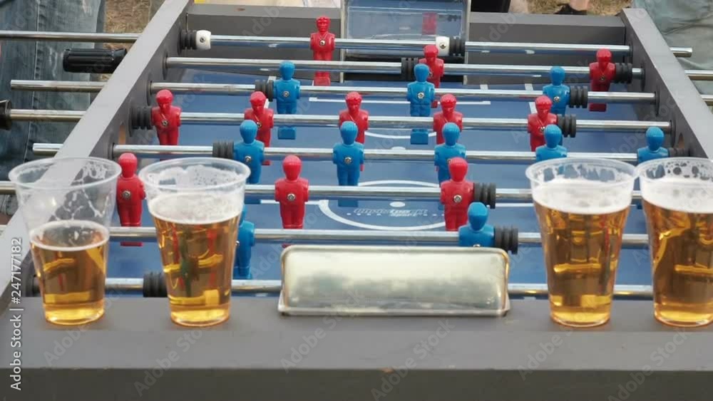 Vídeo do Stock: Young people play table football and drink beer ...