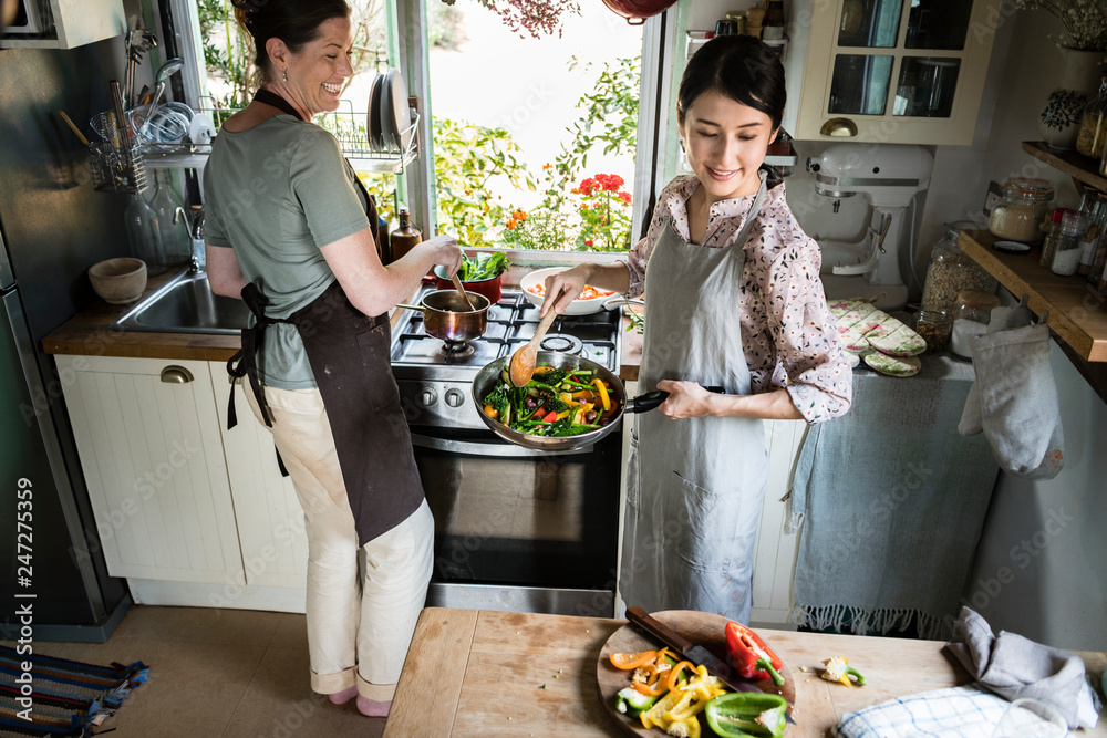Japanese woman cooking stir fried vegetables Stock Photo | Adobe Stock