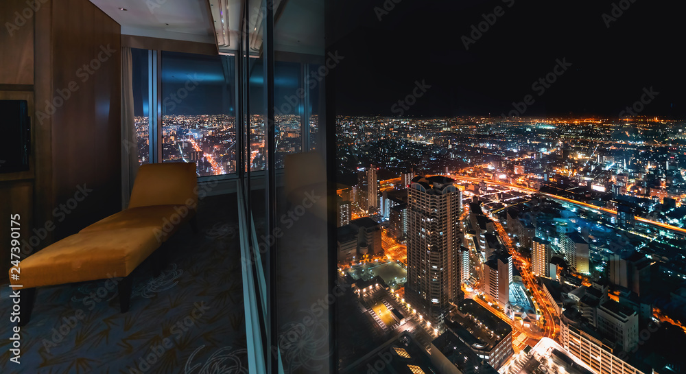 Aerial view of the Osaka skyline at night through a skyscraper window ...
