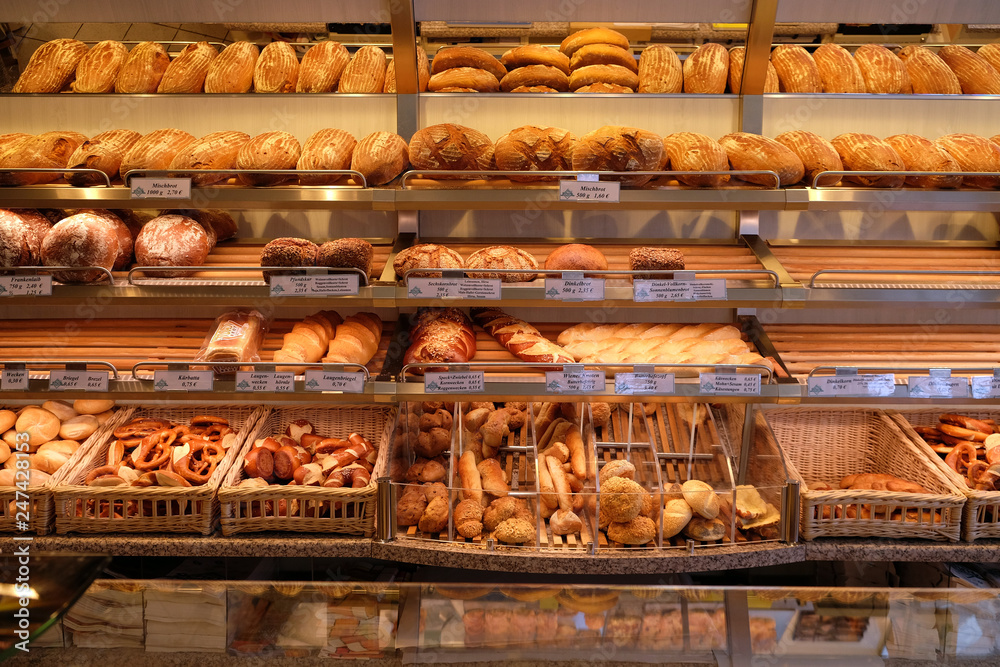 Modern bakery with different kinds of bread, cakes and buns in ...