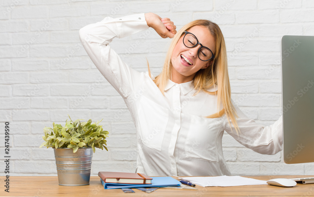 Portrait of young student sitting on her desk doing tasks listening to ...