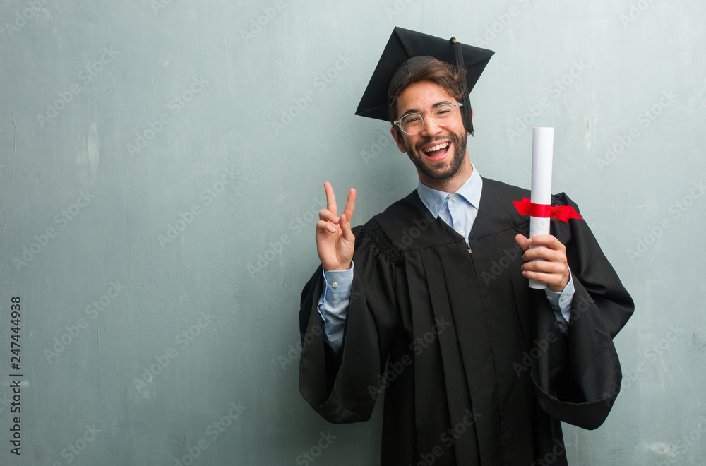 Young graduated man against a grunge wall with a copy space fun and ...