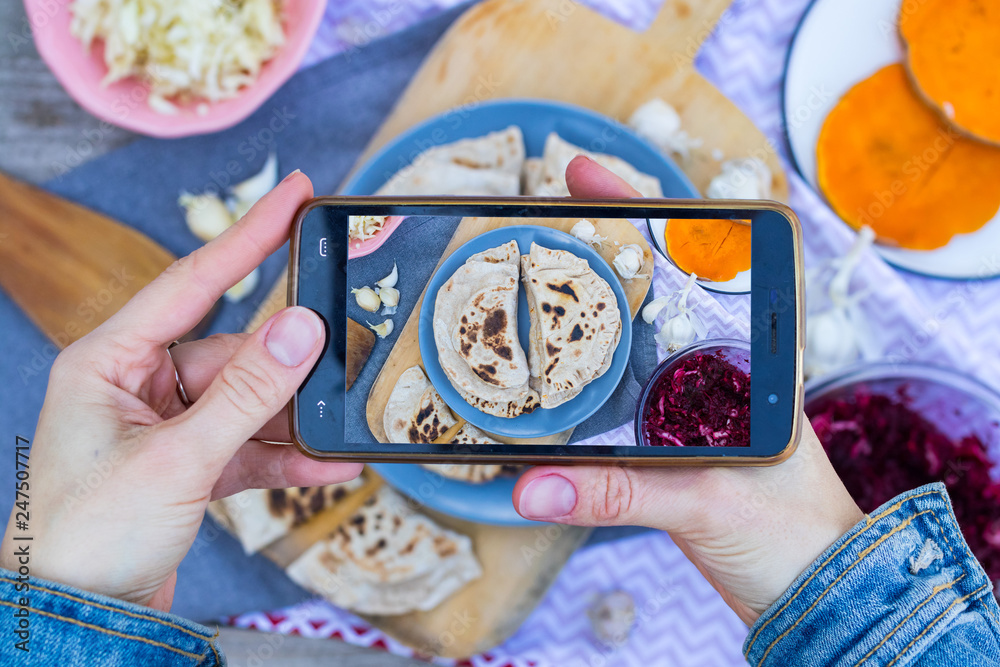 Smartphone food photography. Woman hands holds phone and take photo of ...