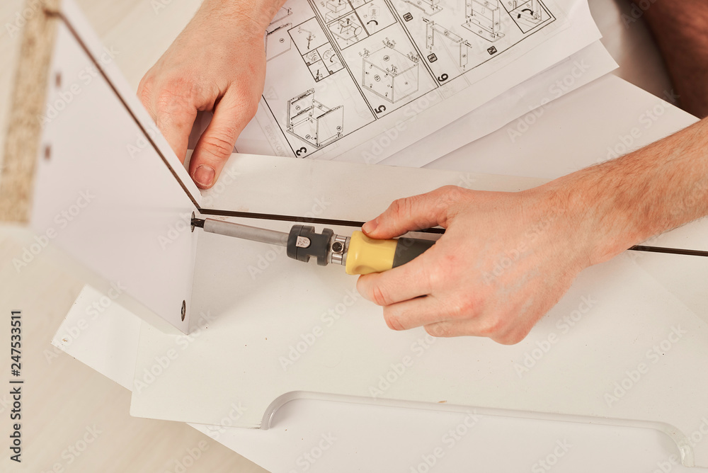 Foto de The furniture assembler joins together the two parts of the ...