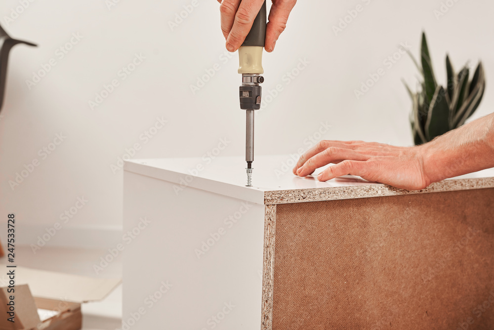 The furniture assembler joins together the two parts of the ready-to ...