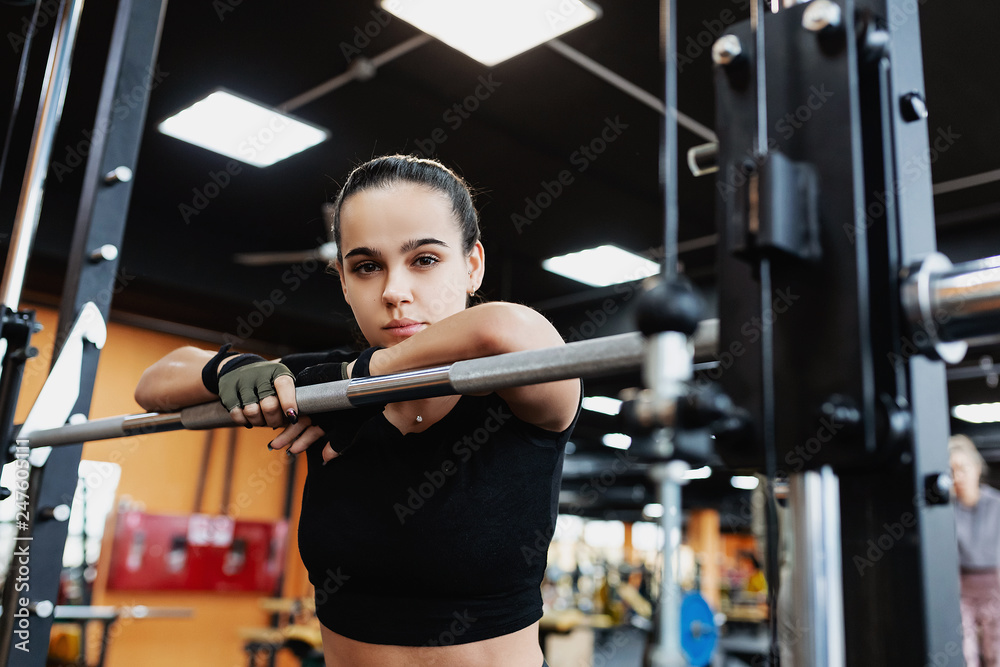Portrait of a beautiful young posing female standing near the bar ...