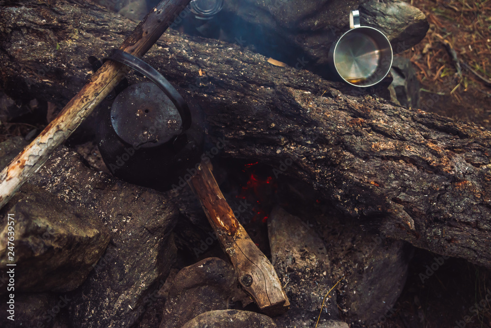 Foto de Extinguished bonfire with kettle on large firewood. Extinct ...