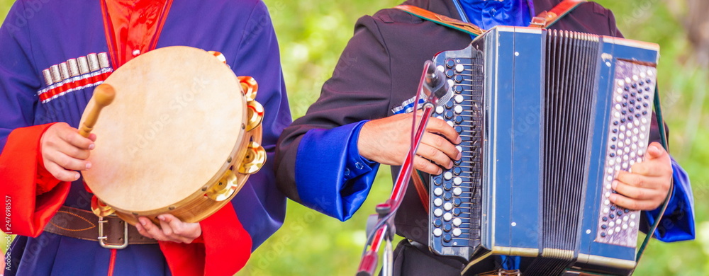 Russian harmonica with three rows and tambourine in the hands of ...