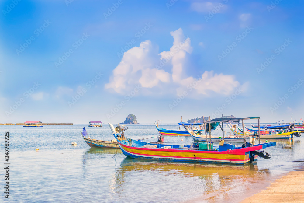 Traditional Asian fishing boats with nets parked off the coast before ...