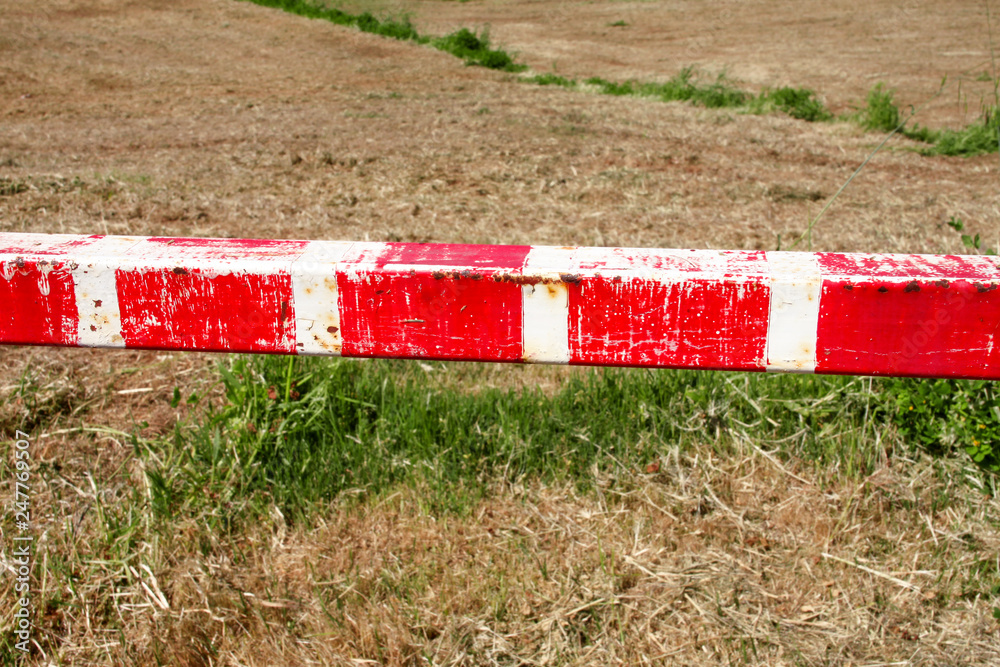 Warning sign, detail of red and white sign barrier on green grass in ...