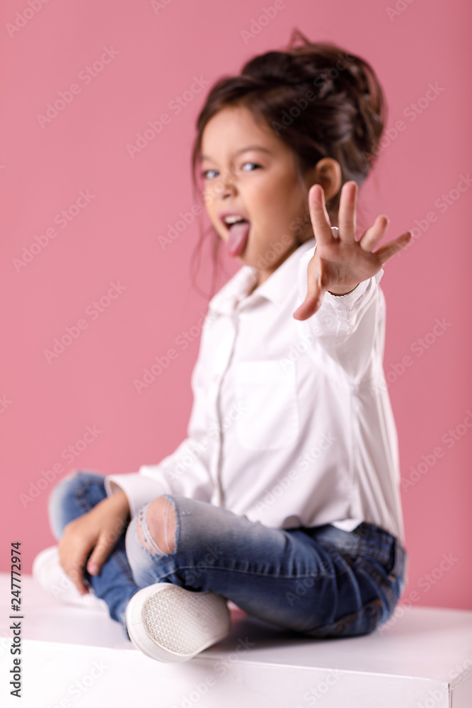 Cute little child girl in white shirt with hairstyle showing tongue on ...