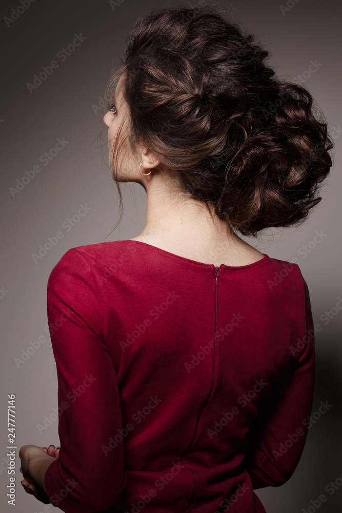 Back view of brunette woman with stylish haircut of curly hair turned ...