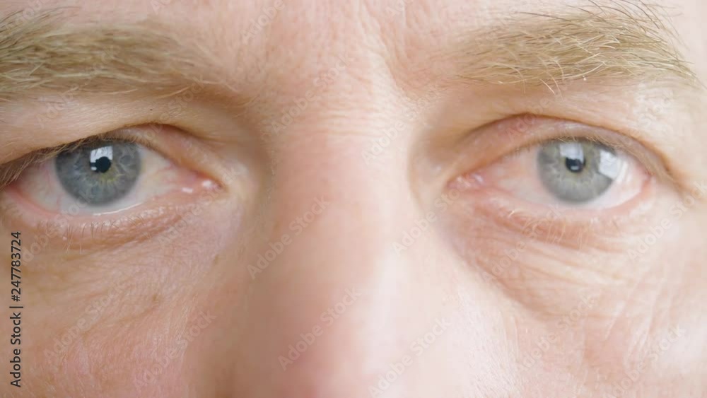 Close up eyes and face adult man. Senior man looking and winking front ...