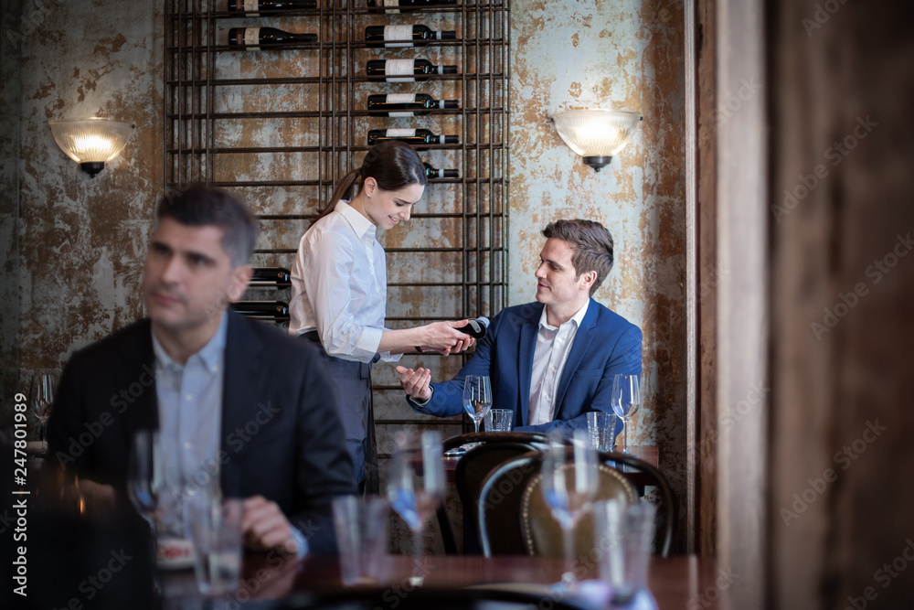 Waitress taking payment in a restaurant Stock Photo | Adobe Stock