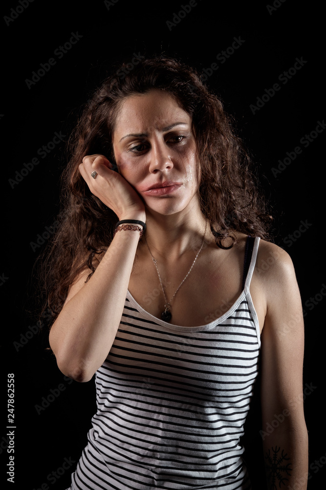 closeup portrait of a scared woman crying with bruises and wounds marks ...