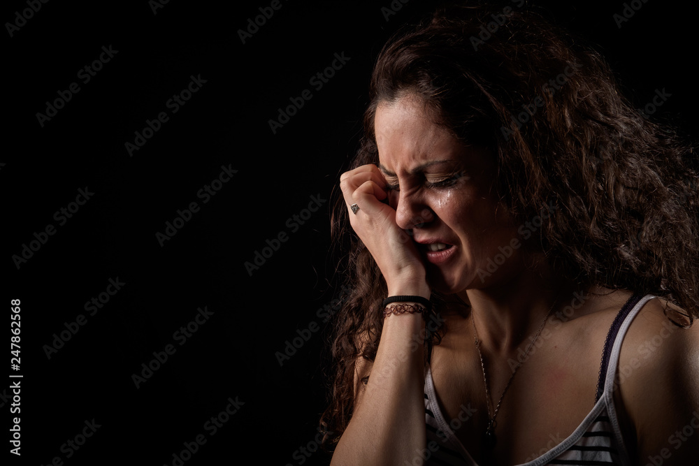 closeup portrait of a scared woman crying with bruises and wounds marks ...