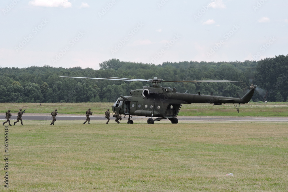 Soldiers getting in a military helicopter and lying on the ground ...