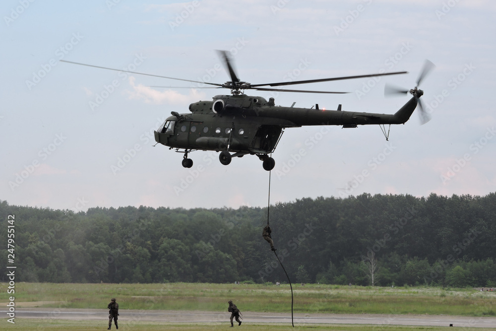 Deploying troops from a military helicopter using fast-roping technique ...
