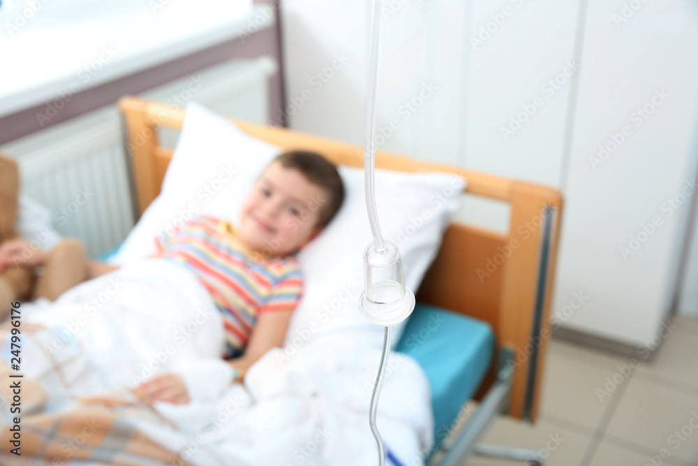 Little child with intravenous infusion in hospital bed, focus on drip ...