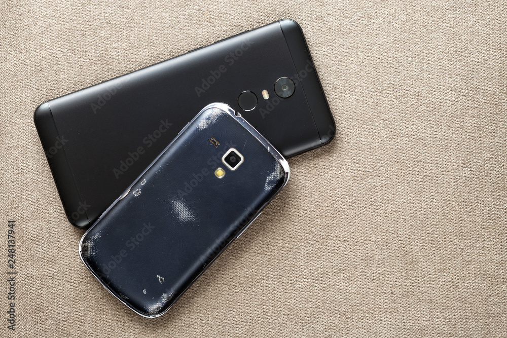 Comparison of two black mobile phones, old cellphone and new modern on ...