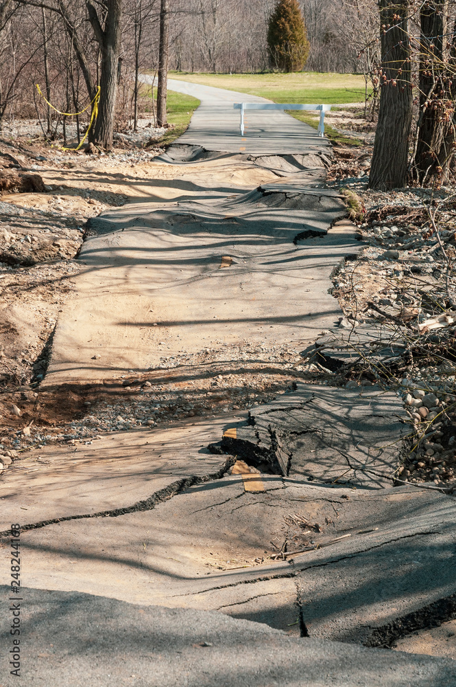 Pavement torn up by flooding on Blackstone River bike path Stock Photo ...