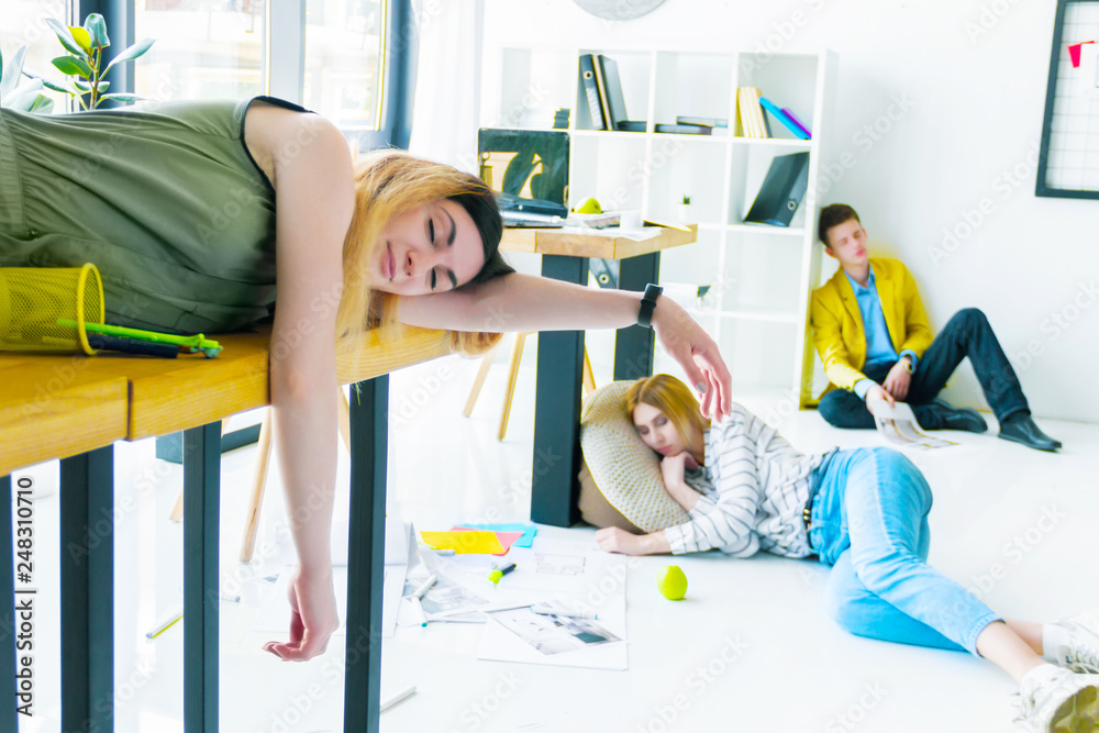 Tired young woman architect interior designer is sleeping on desktop in ...