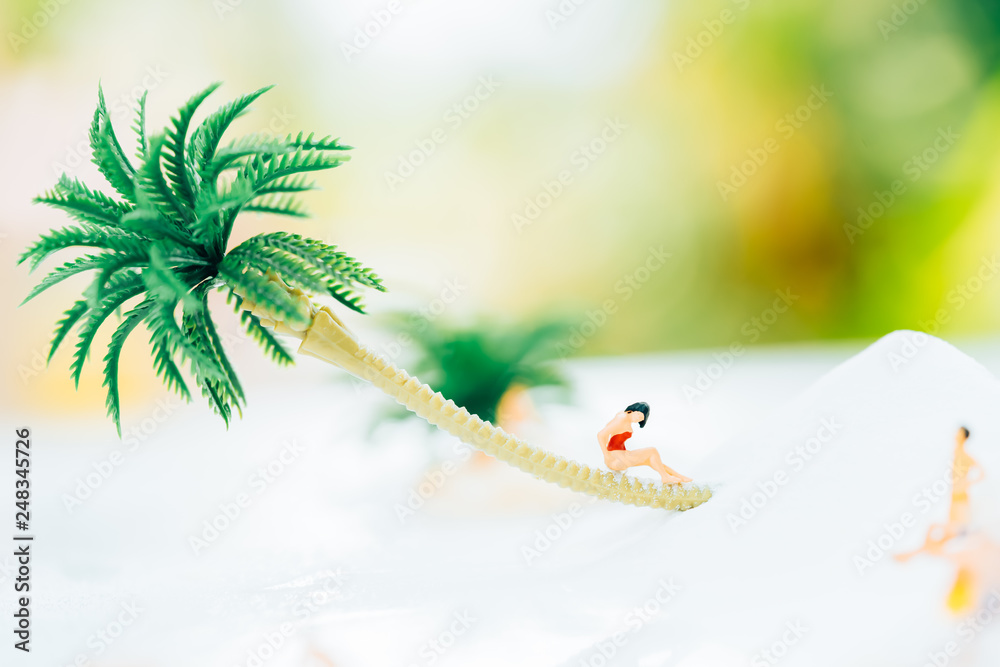 Miniature people : small figures wearing swimsuit relaxing on the beach ...