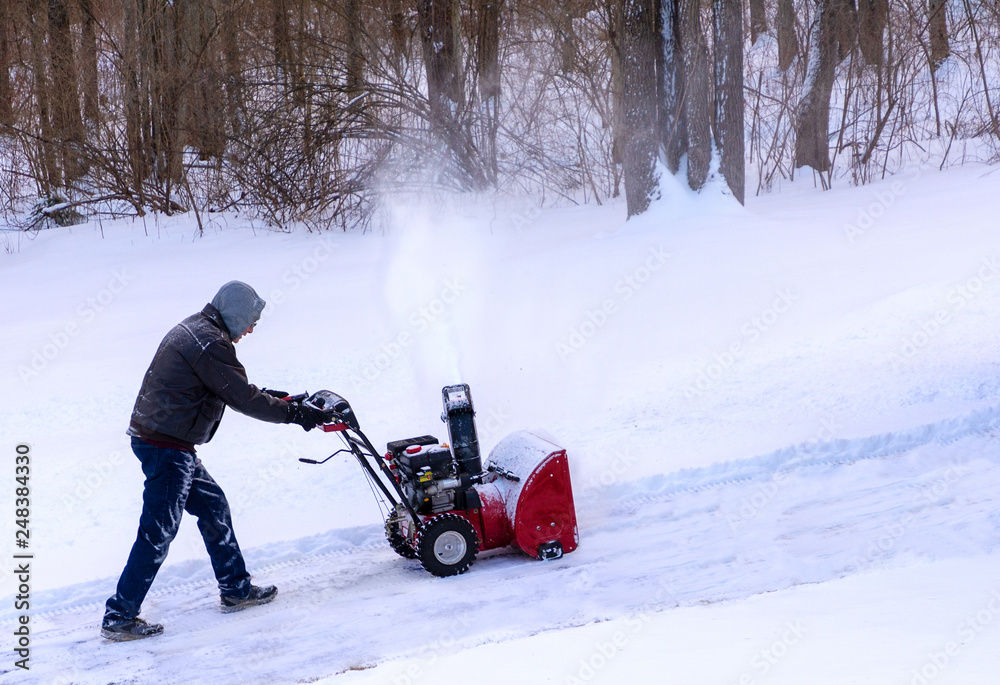 Man using snowblower to clear an uphill driveway Stock Photo | Adobe Stock