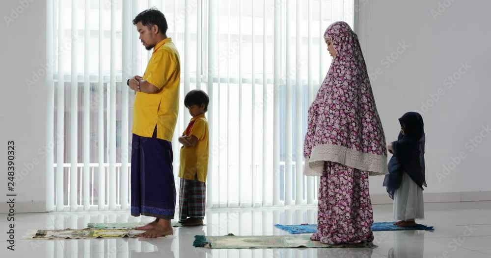 Muslim family with two children praying together at home. Shot in 4k ...