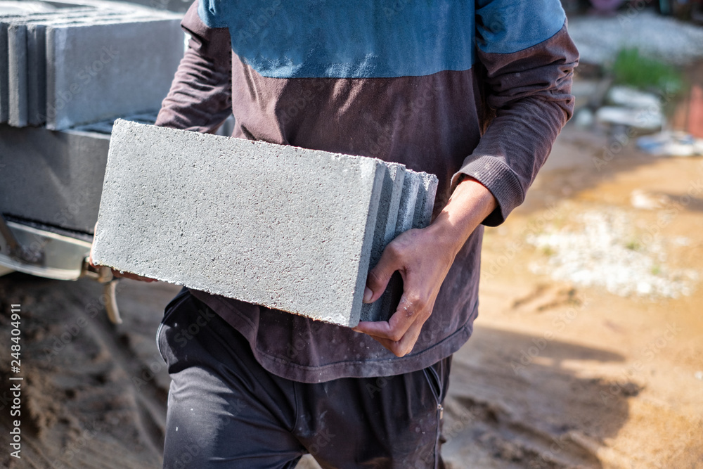 Worker man carry bricks for house construction. Worker carrying a heavy ...