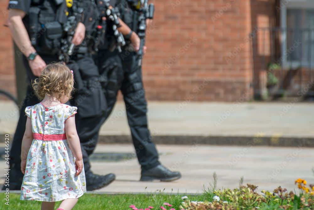 little girl walks in front of armed police patrol in tourist town ...