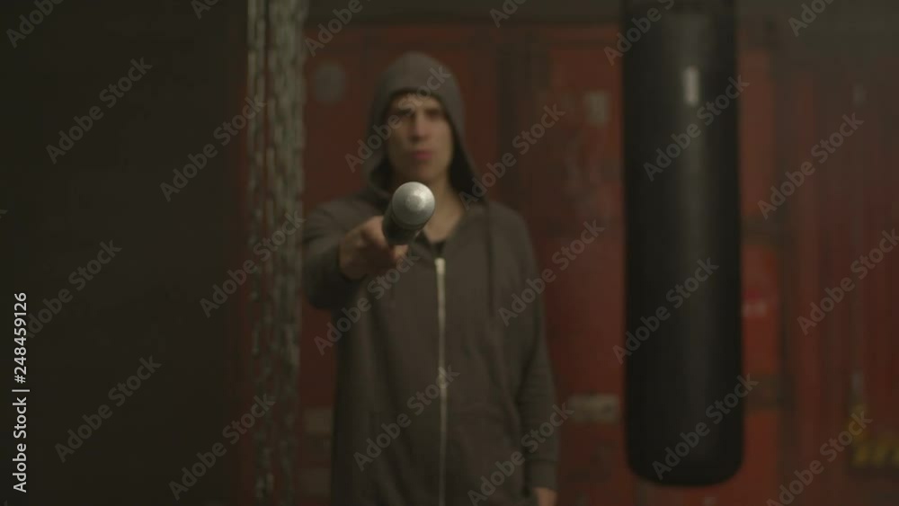 Aggressive grim looking hoodlum in hoodie with outraged look pointing ...