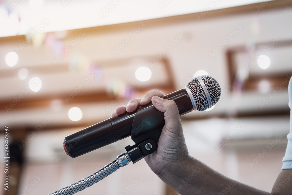 Speaker holding microphone for speaking, presentation on stage in ...