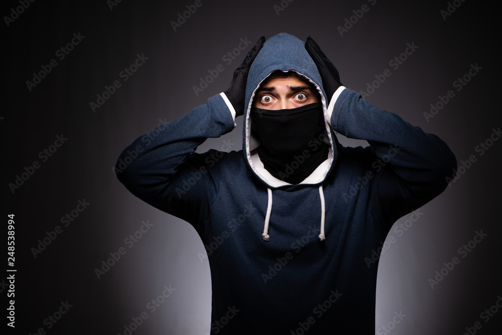 Young gangster in hood on grey background Stock-Foto | Adobe Stock