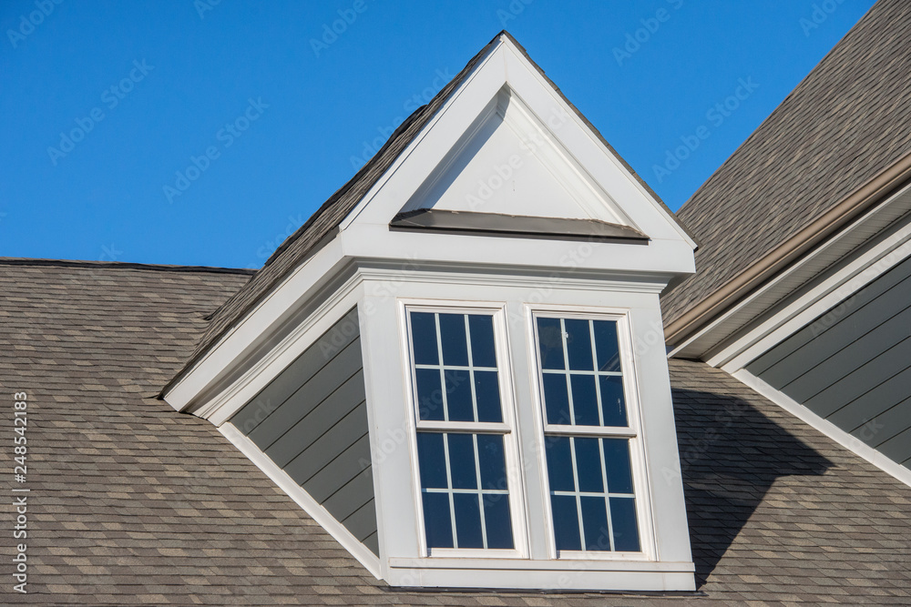 Plakat white dormer sash window on a gable roof with vinyl siding on a ...