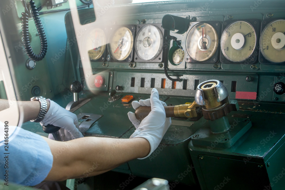 Hand in white gloves of Japanese rail driver check joystick in cab of ...