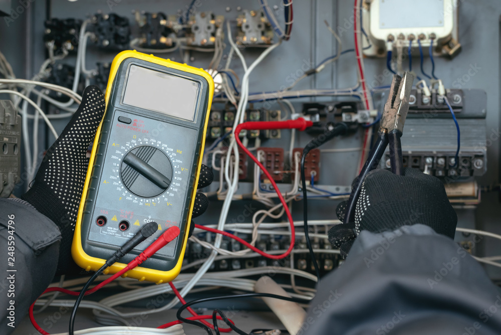 Electrician is checking the voltage in the electrical circuit of the ...
