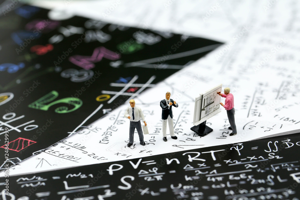 Miniature people : teacher and friend with Math problems on graph paper ...