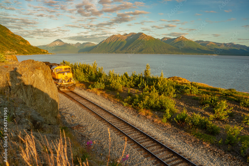 Alaska Denali Star train passing along tracks next to lake with ...