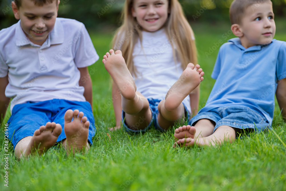 Happy children show their feet close up in the park. Barefoot on the ...