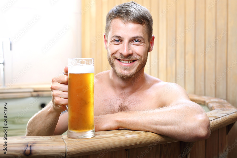 Męskie spa. Przystojny mężczyzna zażywa kąpieli w bali z woda termalną ...