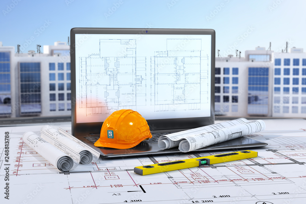 Laptop with construction tools and drawings on the background of ...