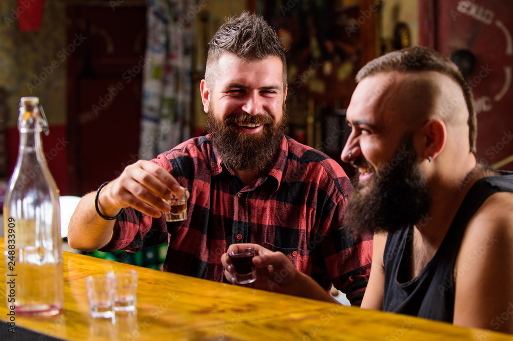 Hipster brutal man drinking alcohol with friend at bar counter. Men ...