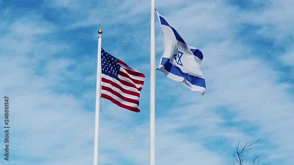 American and Israeli flags waving in the wind with a blue sky with ...