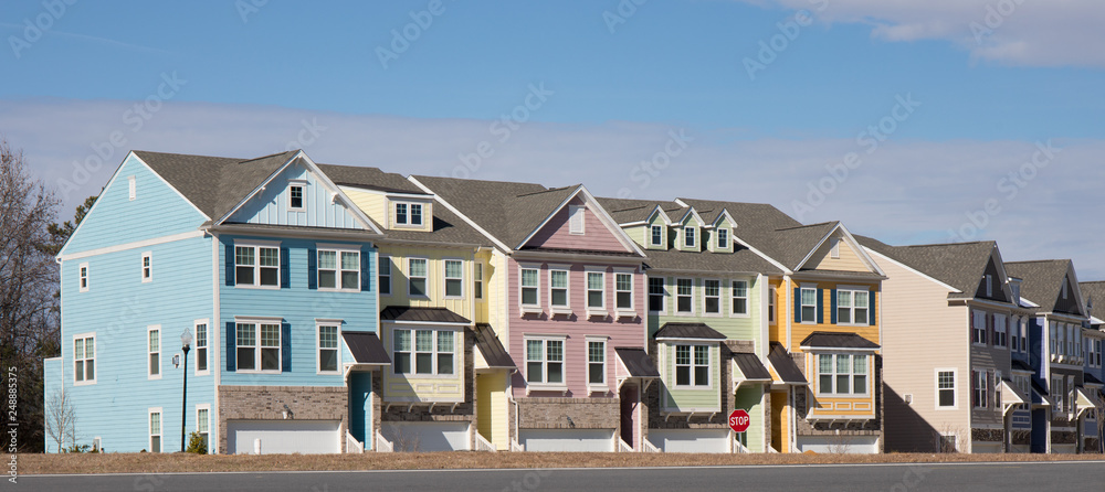 A row of brightly colored townhouses with bright blue sky. Stock Photo ...