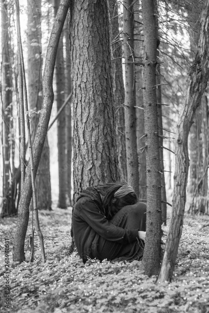 The girl in the forest is sad from loneliness. The girl is crying in ...