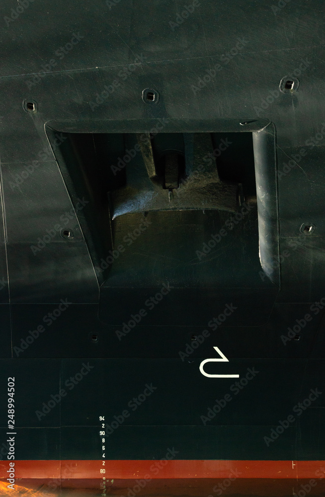 Detail of raised anchor, draft markings and waterline on hull, port ...